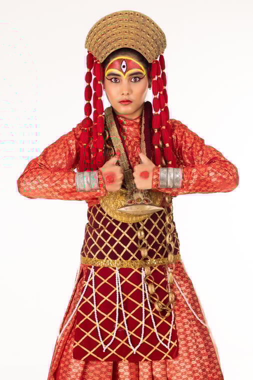 A beautiful girl dressed as Goddess Kumari in a dancing pose - Photos Nepal