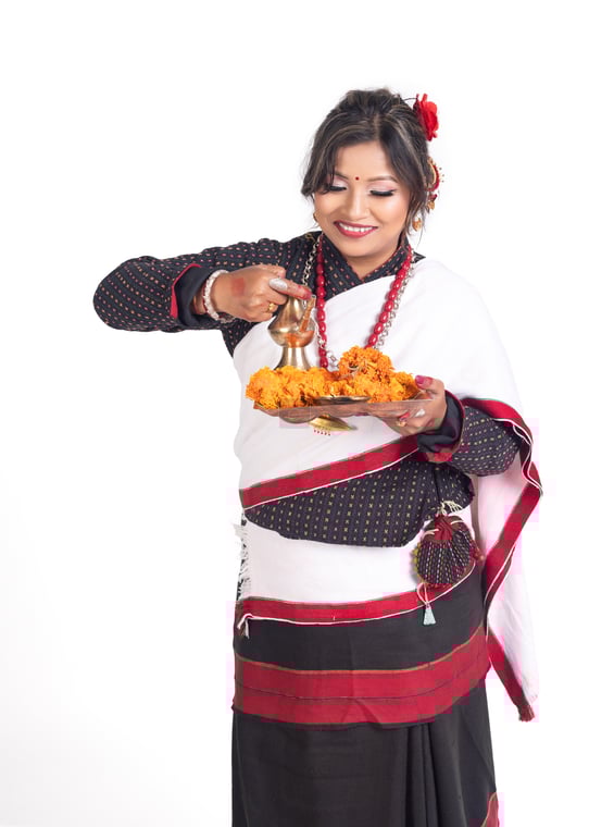 A happy Newari woman holding Puja set while wearing traditional dress ...