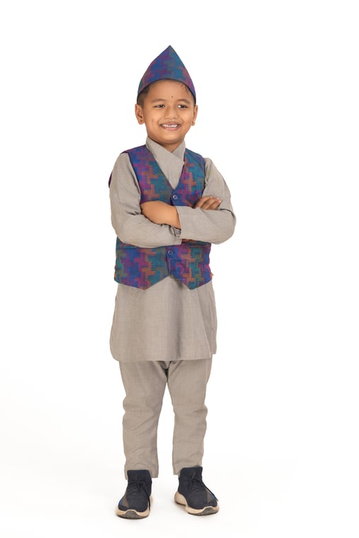 A happy young boy folding his hand in the iconic Nepali Daura Surwal ...