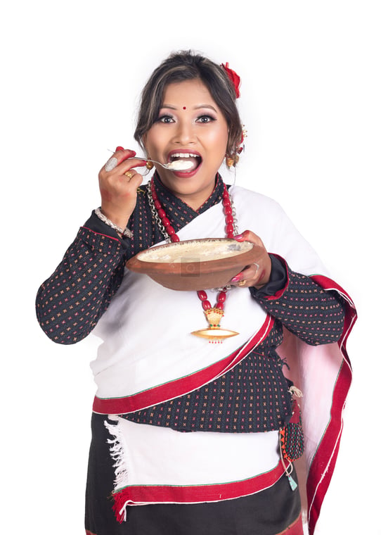 A middle-age Newari woman tasting Dahi while wearing Newari cloth ...