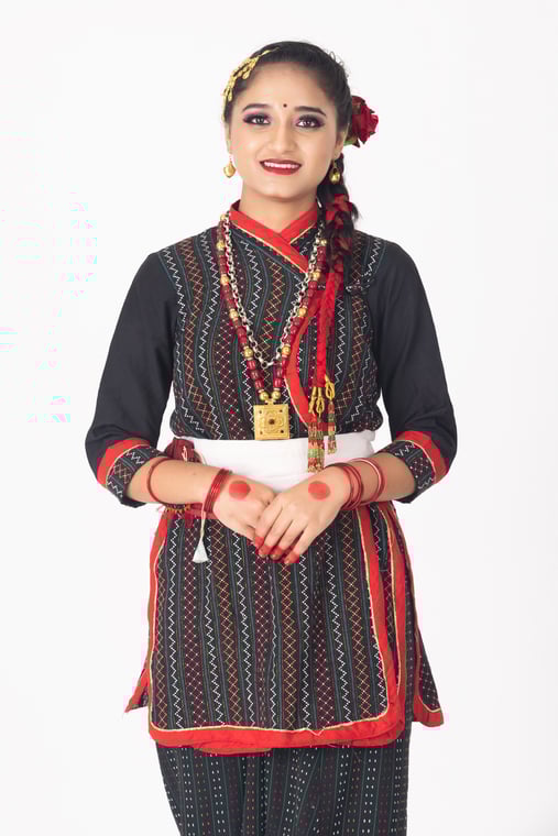 A joyful girl with cultural Newari attire stands with hands clasped ...