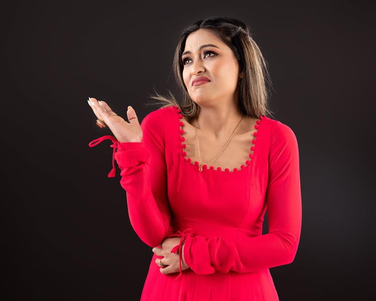 Embarrassed Nepali Woman in Red Dress Cringing, Smiling Awkwardly ...