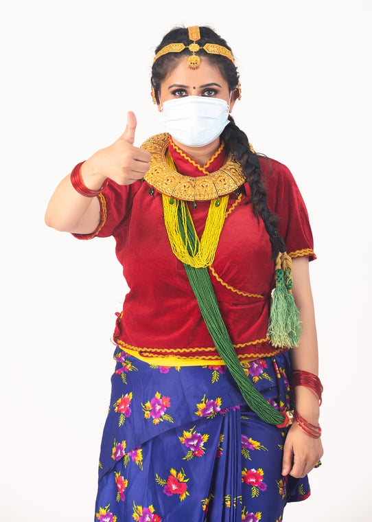 A traditionally dressed Nepalese woman wearing a mask - Photos Nepal