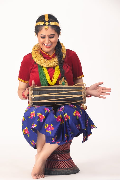 Traditionally dressed Nepali woman playing Madal - Photos Nepal